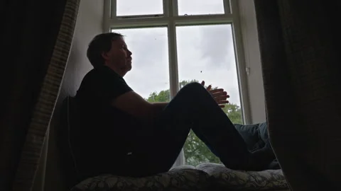 A man sitting in window in high contrast... | Stock Video | Pond5