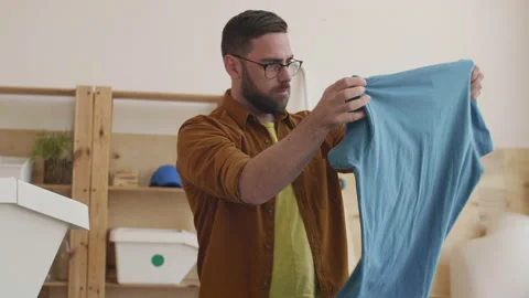 Man Sorting Clothes in Old Clothes Recyc... | Stock Video | Pond5