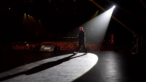 A man stands on the stage and looks into... | Stock Video | Pond5