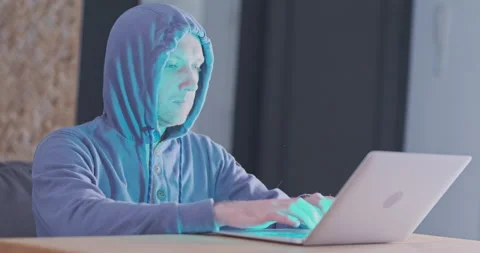 Man starts working on computer. Hooded p... | Stock Video | Pond5