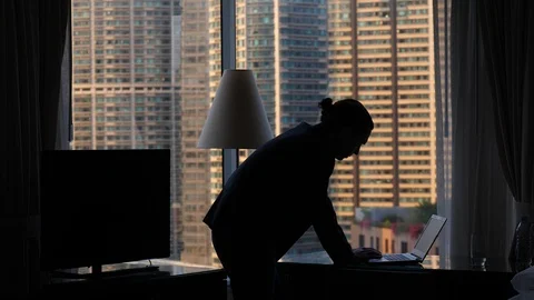 Man stay bend over laptop at table, silh... | Stock Video | Pond5