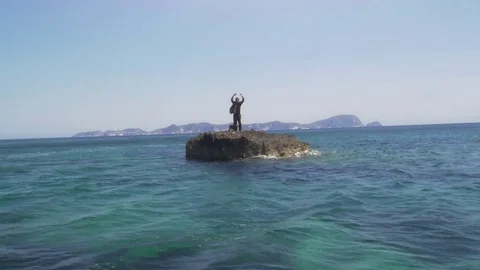 Man in suit stranded on a deserted rock ... | Stock Video | Pond5