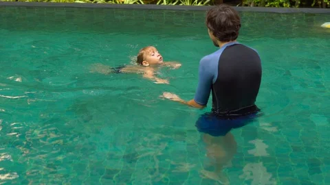 Man swimming instructor teaches little b... | Stock Video | Pond5
