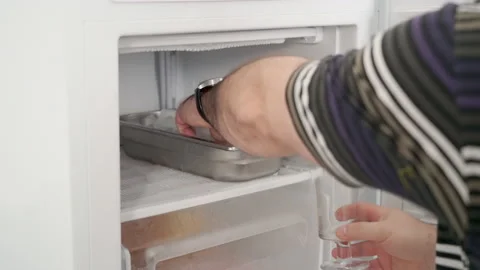 A man takes ice cubes from the freezer o... | Stock Video | Pond5