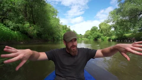 A man talking while floating on a river ... | Stock Video | Pond5