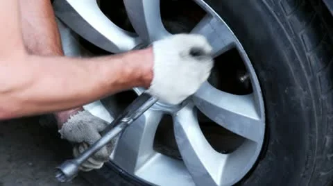 Man tight nuts on car wheel by cross scr... | Stock Video | Pond5