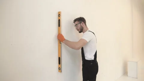 Man in uniform measuring wall level with... | Stock Video | Pond5