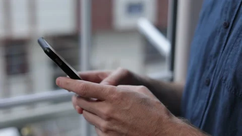 A man uses a smartphone at the window. T... | Stock Video | Pond5