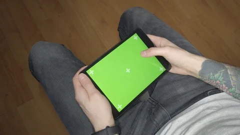 A man uses a tablet. Green screen on tab... | Stock Video | Pond5