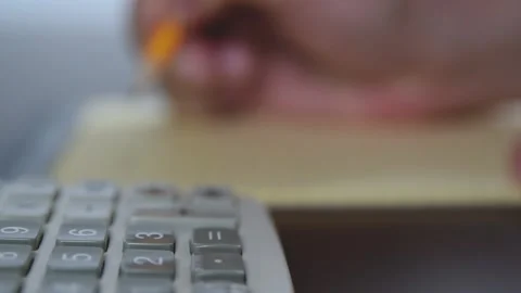 A man using a calculator with notes. | Stock Video | Pond5
