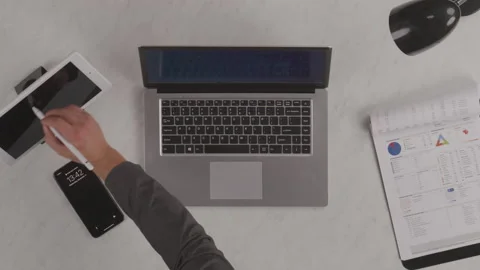 Man Using Multiple Devices on a Desk | Stock Video | Pond5