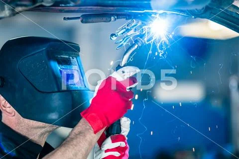 Photograph: Man using welding machine to weld the metal #113601032