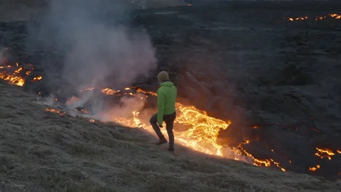 Man Walking Along Lava Flow From Eruptin... | Stock Video | Pond5