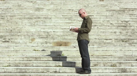 man walking and reading a book | Stock Video | Pond5