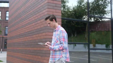 Man Walking and Typing on Tablet, Outdoo... | Stock Video | Pond5