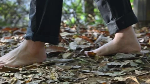 A man walking barefoot on a fallen leafy... | Stock Video | Pond5