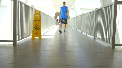 Man walking down walkway with slippery w... | Stock Video | Pond5
