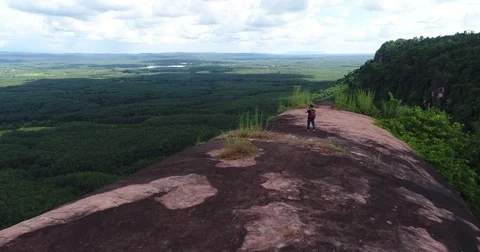 Man walking on the edge of a cliff high ... | Stock Video | Pond5