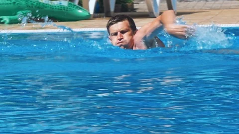 Man walking in the swimming pool on sunn... | Stock Video | Pond5