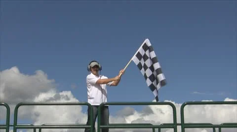 Man waving a checkered flag on a raceway | Stock Video | Pond5