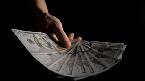a man waving a fan of dollars in the dar... | Stock Video | Pond5