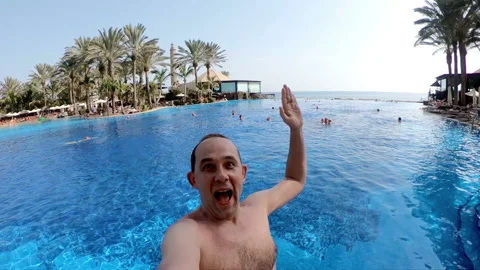 Man waving hand and jumping into the poo... | Stock Video | Pond5