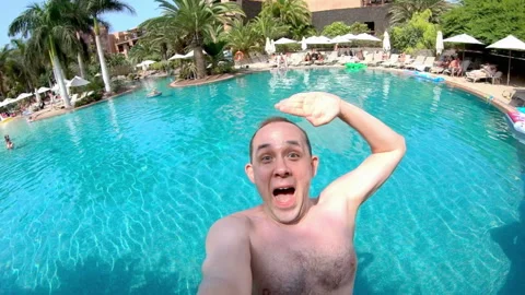 Man waving hand and jumping into the poo... | Stock Video | Pond5