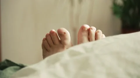 The man wiggles his toes, taking them ou... | Stock Video | Pond5