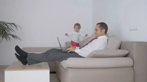 Man work at computer, baby child walk on... | Stock Video | Pond5