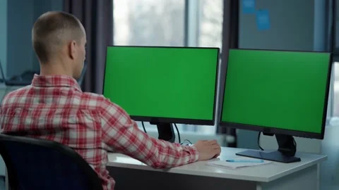 Man Working On Computer With Two Green S... | Stock Video | Pond5