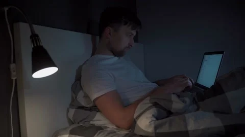 Man working on laptop in bed at night. G... | Stock Video | Pond5