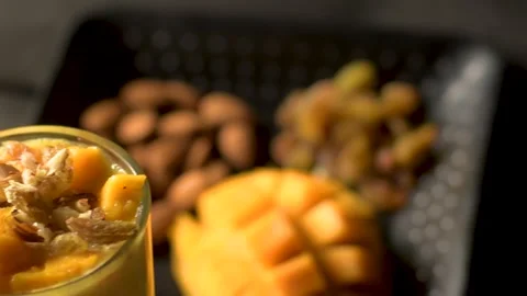 Mango slices and chopped nuts on top of ... | Stock Video | Pond5