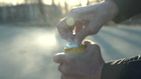 A man's hand opens a shaken can of beer | Stock Video | Pond5