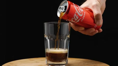 A man's hand pours a Coca-Cola from a ca... | Stock Video | Pond5