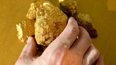 Man's hand puts a large gold nugget on a... | Stock Video | Pond5
