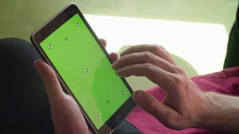 Man's hand scrolling a tablet with green... | Stock Video | Pond5