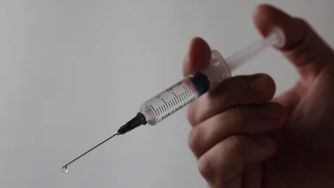 Man's hand slowly presses on a syringe w... | Stock Video | Pond5