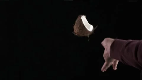 Man's hands throw up coconut cut in half... | Stock Video | Pond5