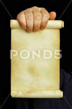 Manuscript Hand holding old manuscript over black background Copyright ...
