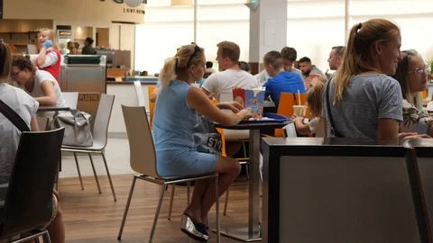 Many people sit eating fast food dishes ... | Stock Video | Pond5