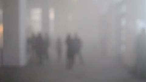 Many people walk in a smoke filled room | Stock Video | Pond5