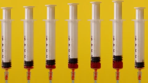 Many syringes fill with blood on a yello... | Stock Video | Pond5