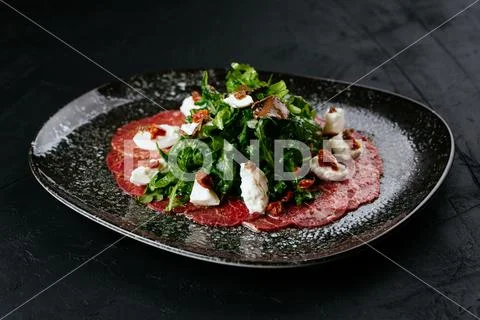 Photograph: Marble beef carpaccio on a black background #144134342