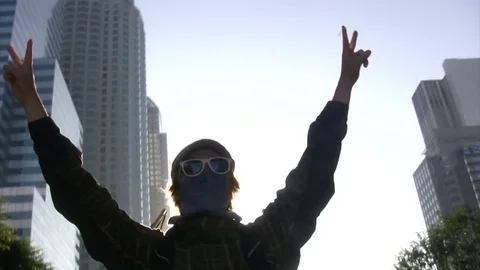 Masked protester marches with peace sign... | Stock Video | Pond5