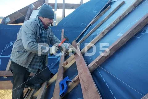 Photograph: The master clogs the nail into a beam, fixing this ...
