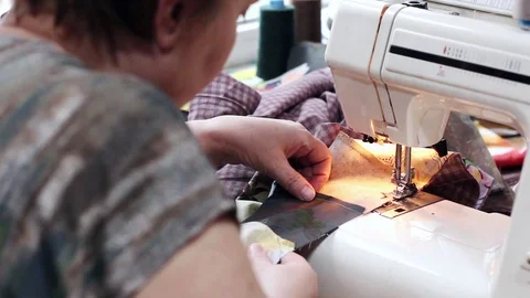 Mature woman is stitching by sewing mach... | Stock Video | Pond5
