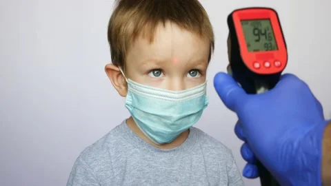 A measuring the boys temperature using a... | Stock Video | Pond5