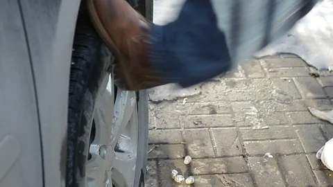 Mechanic to kick the wheel of the car to... | Stock Video | Pond5