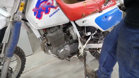 Mechanic putting kick stand down on moto... | Stock Video | Pond5