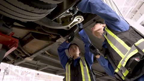 Mechanics working under bus in maintenan... | Stock Video | Pond5